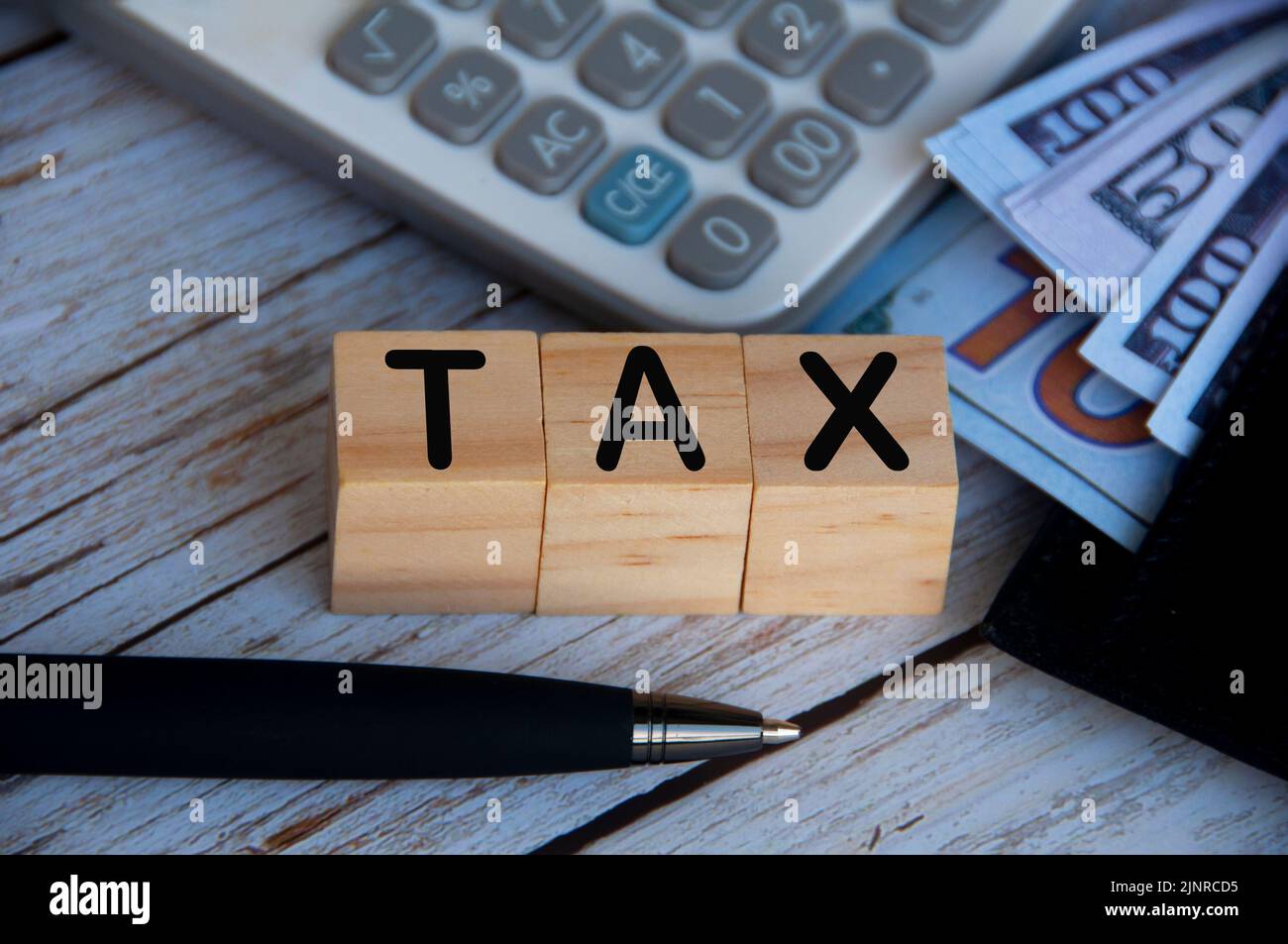 Tax word on wooden blocks with calculator and bank notes background ...