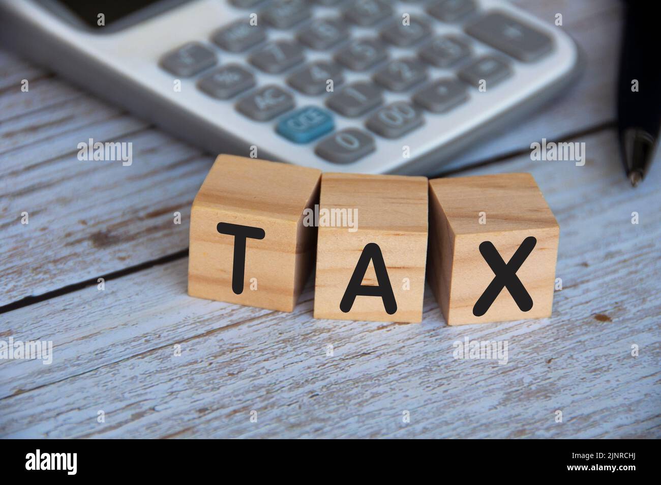 Tax word on wooden blocks with calculator background. Tax concept Stock ...