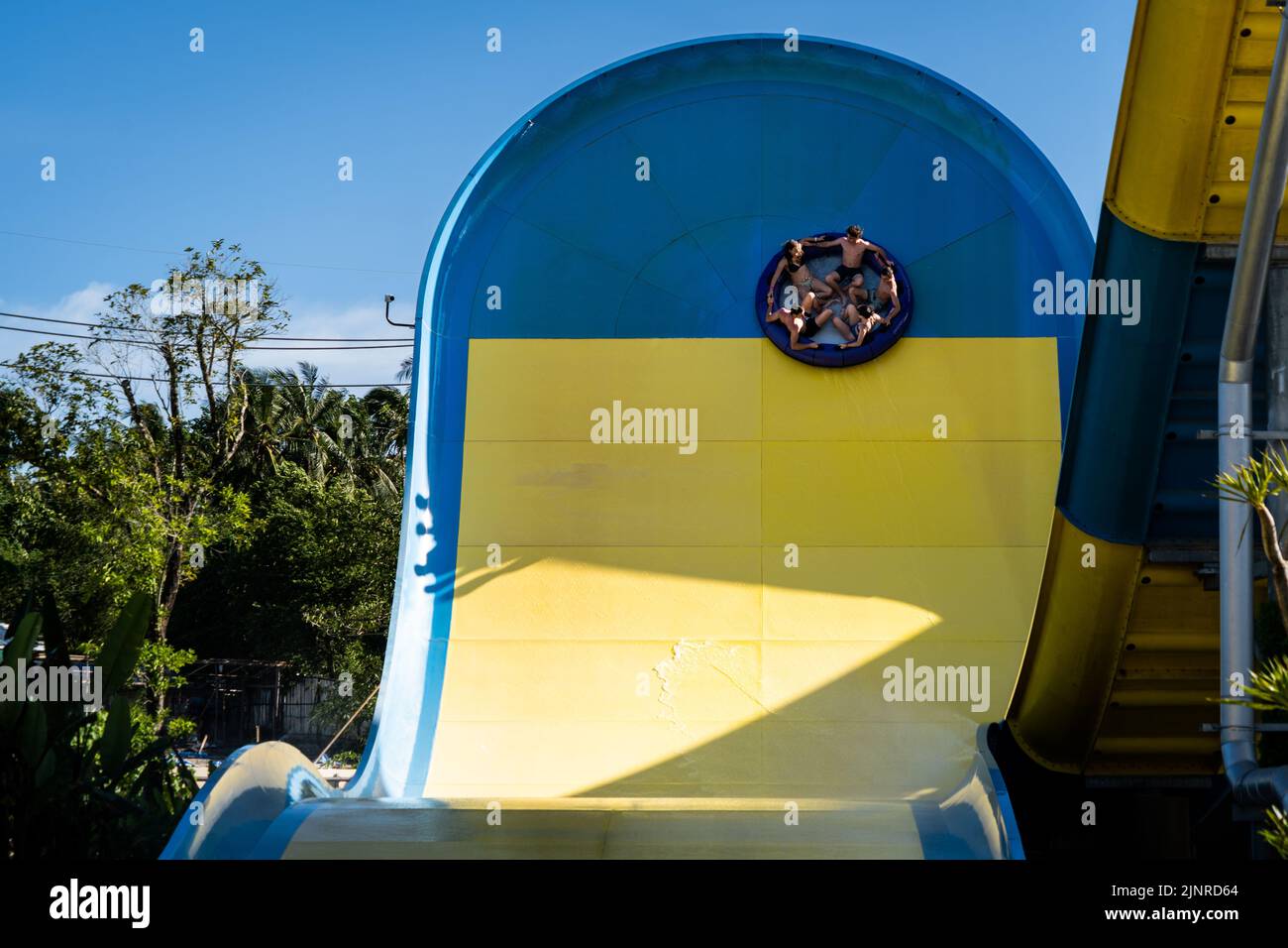 A group of people are seen in a large raft on the side of a steep water ...