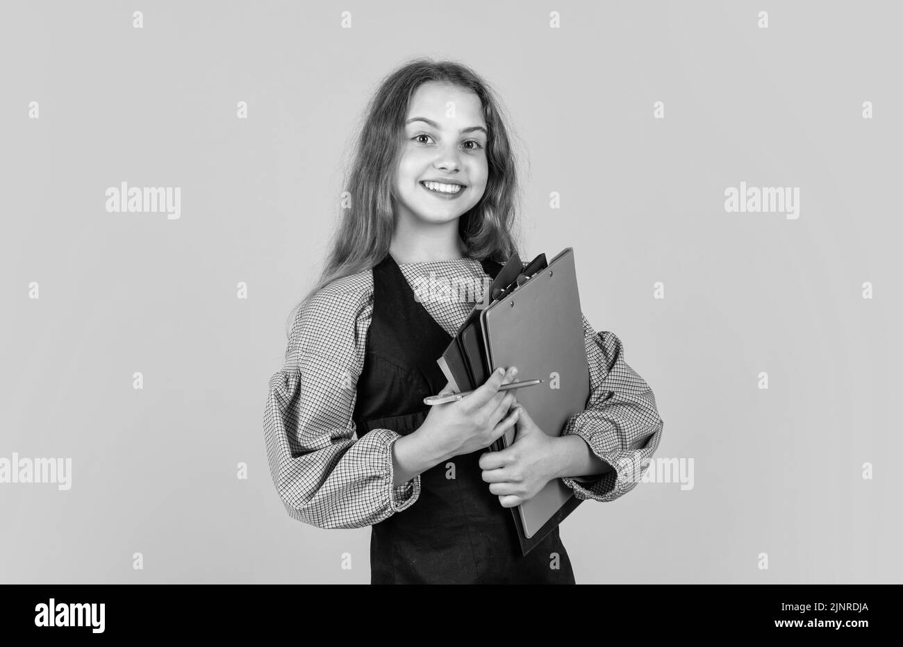 stylish child girl working with paper documents in folder, back to ...