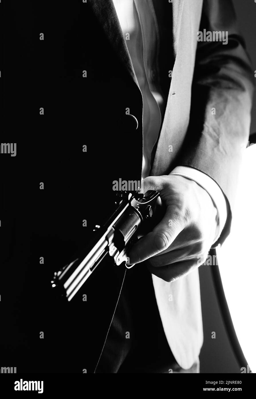Retro secret agent with pistol revolver gun in hand in vintage crime ...