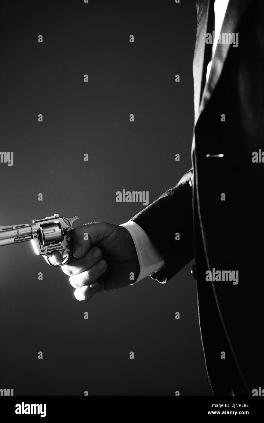 Retro secret agent with pistol revolver gun in hand in vintage crime ...