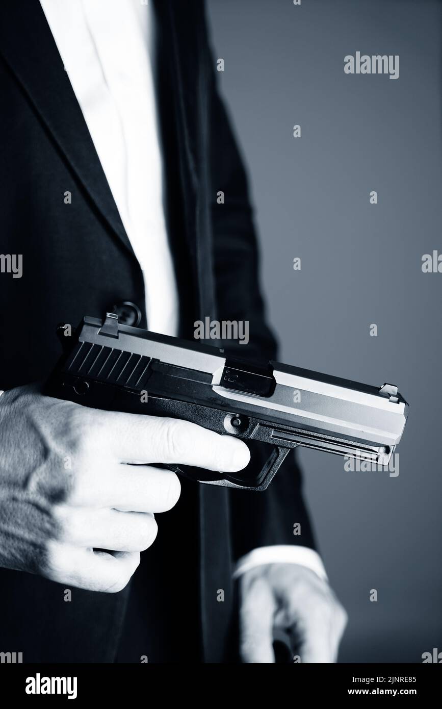 Retro secret agent with pistol revolver gun in hand in vintage crime ...