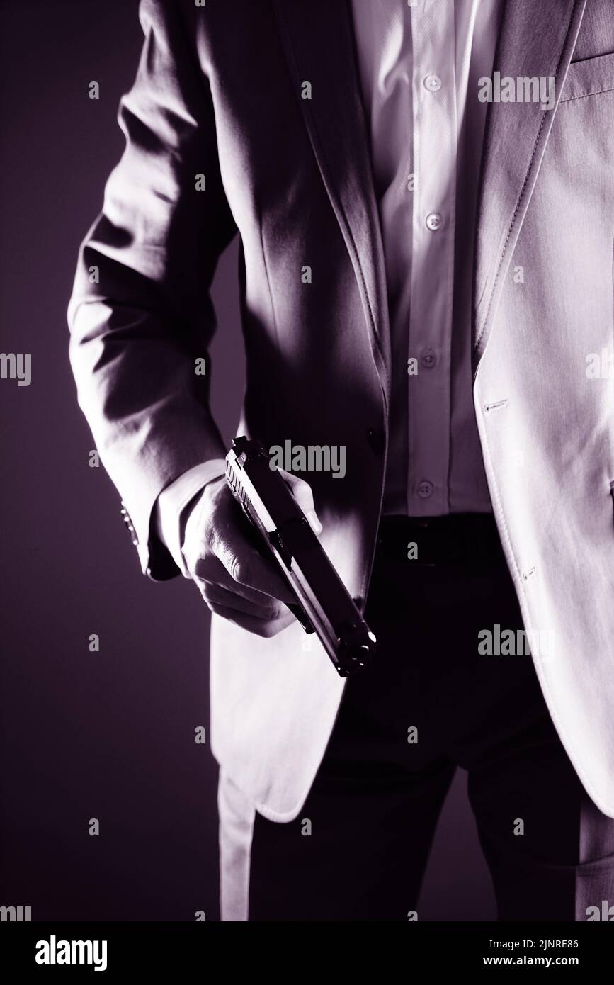 Retro secret agent with pistol revolver gun in hand in vintage crime ...