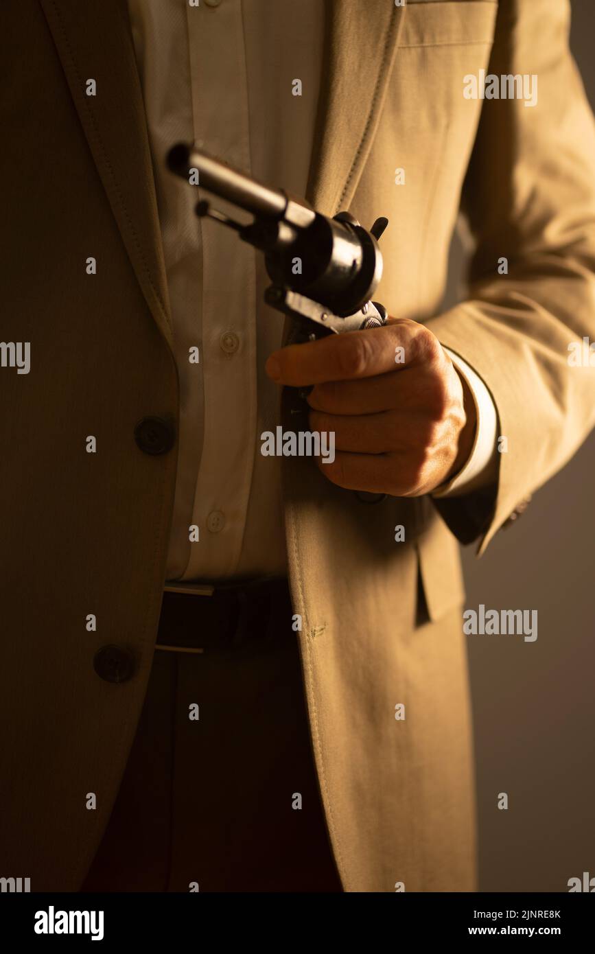 Male detective spy killer holding pistol gun in dramatic novel book ...