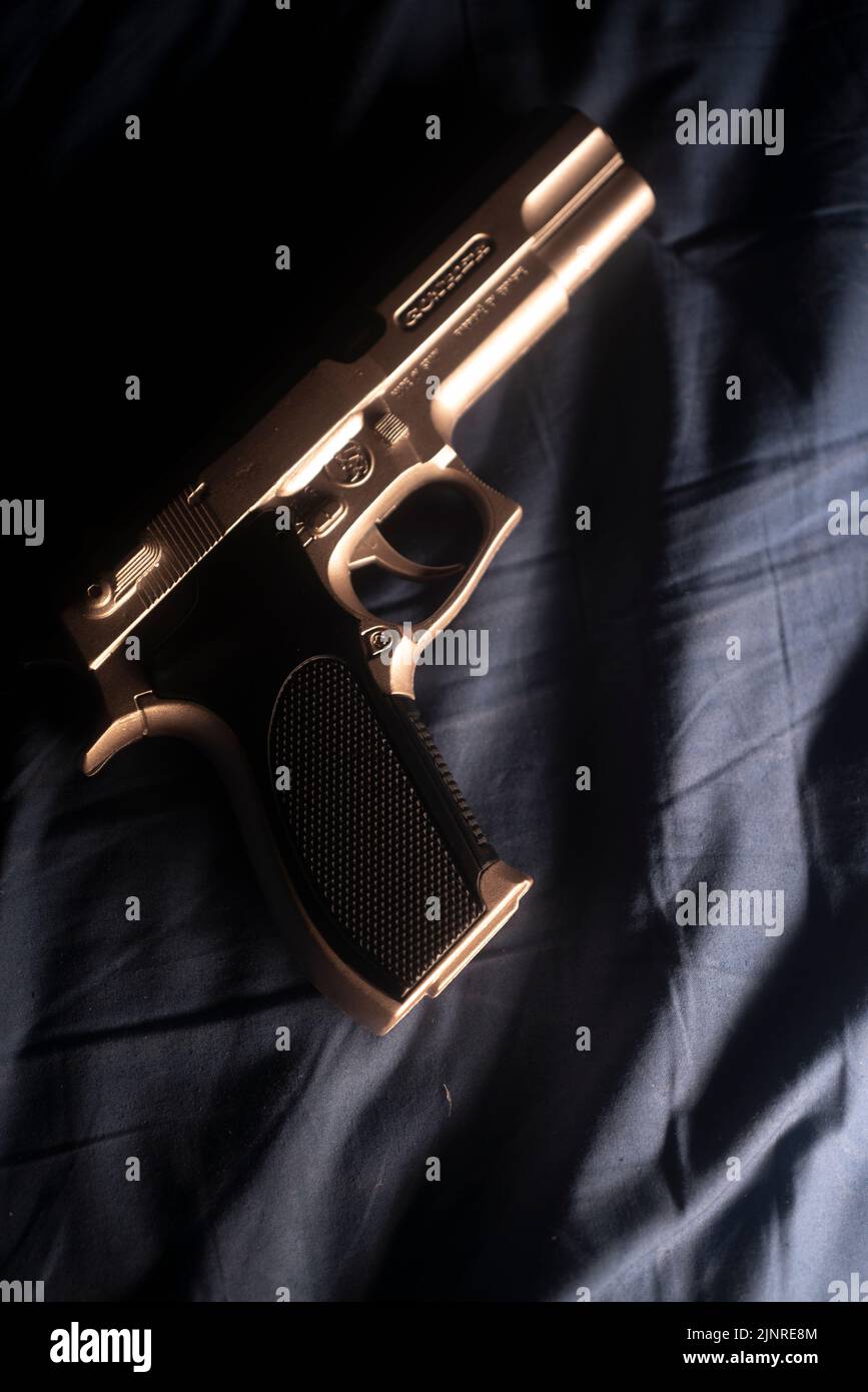 Pistol gun on bed sheet still life crime thriller book cover design ...