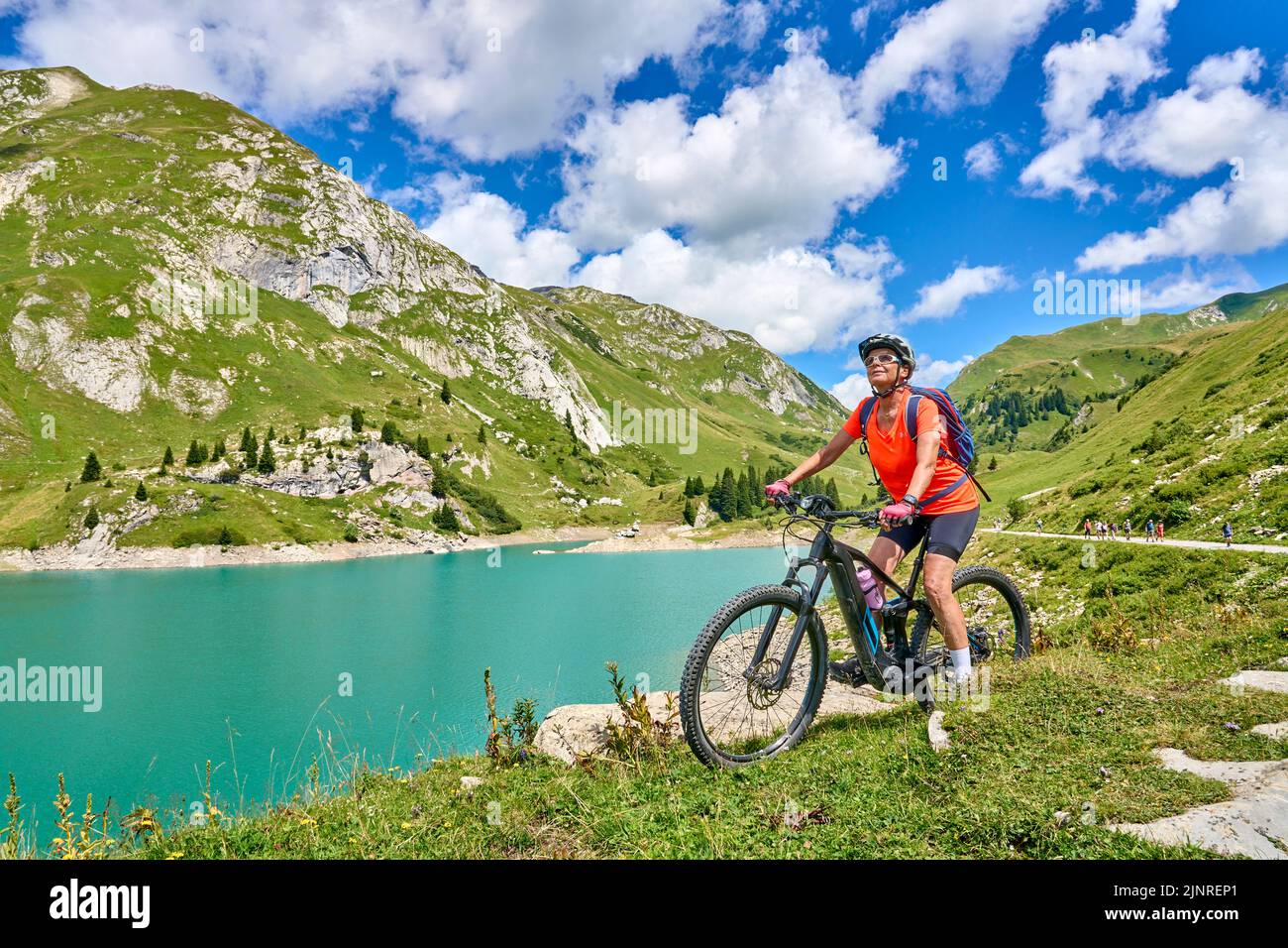 active senior woman, riding her electric mountain bike at Spuller Lake ...