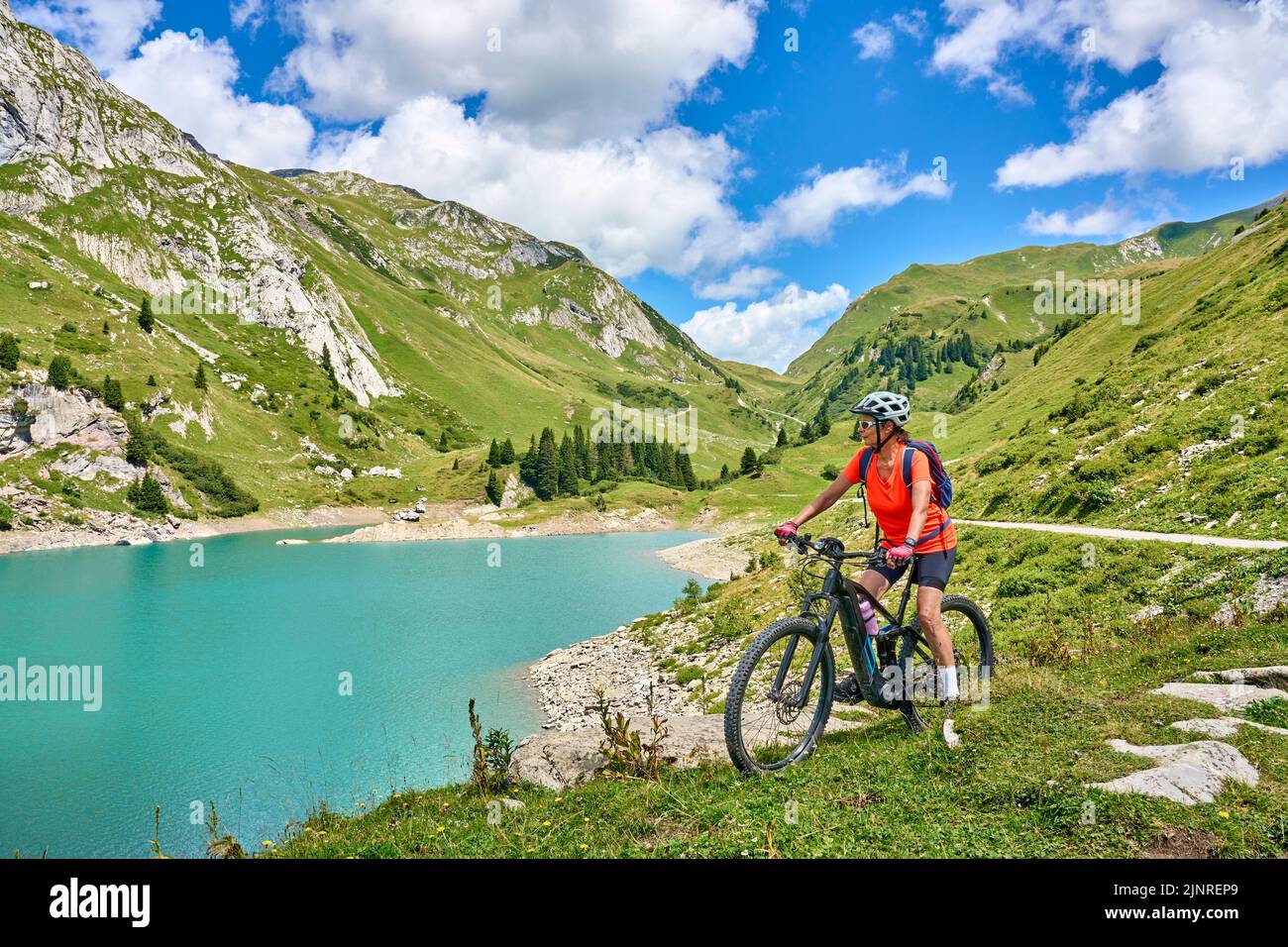 active senior woman, riding her electric mountain bike at Spuller Lake ...