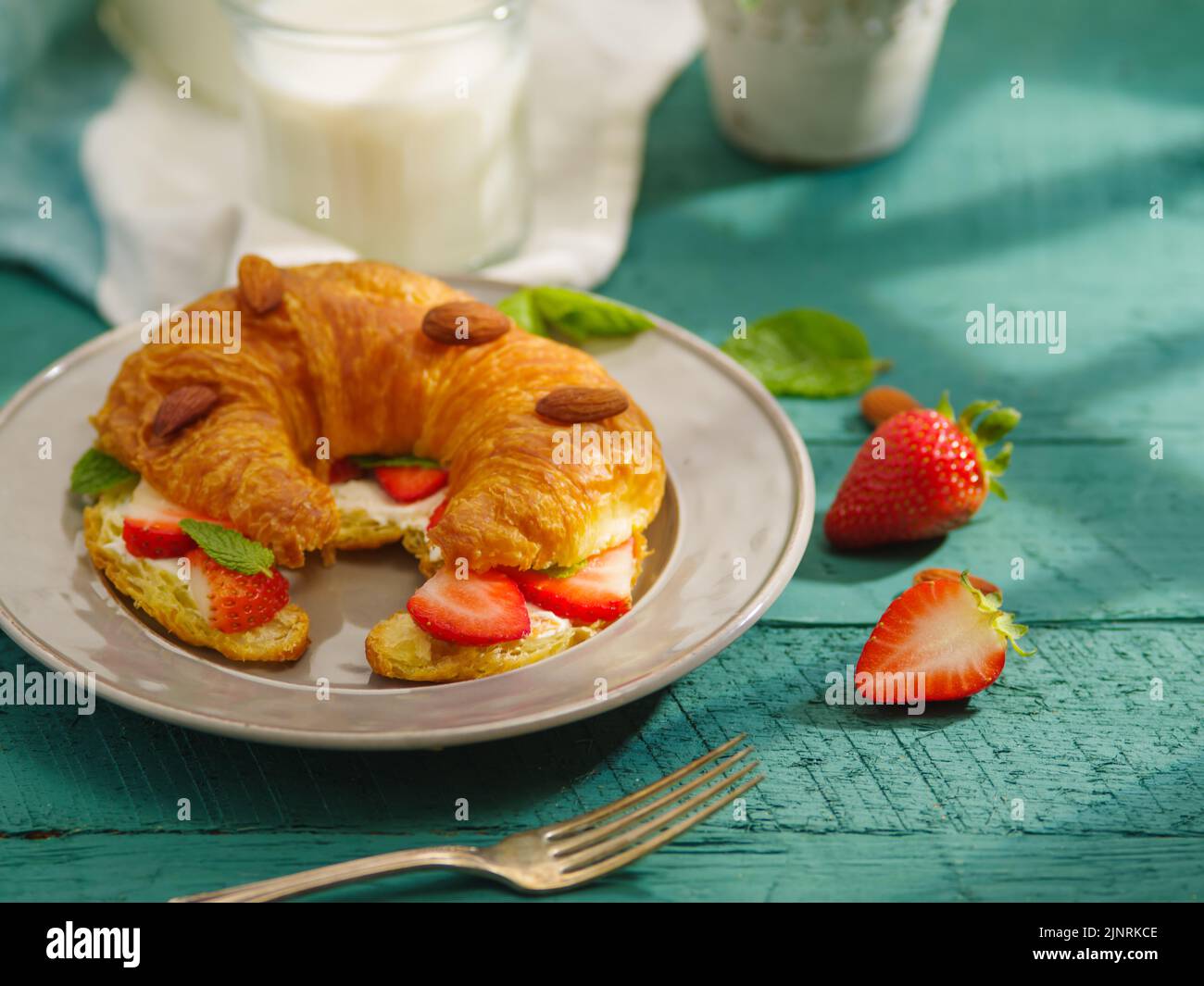 Fresh French croissant with ripe strawberries, almonds and fragrant ...