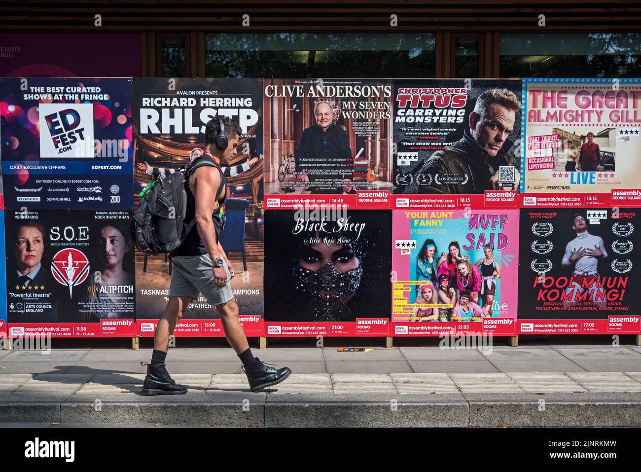 A young man walking by Edinburgh Fringe Festival posters in George ...