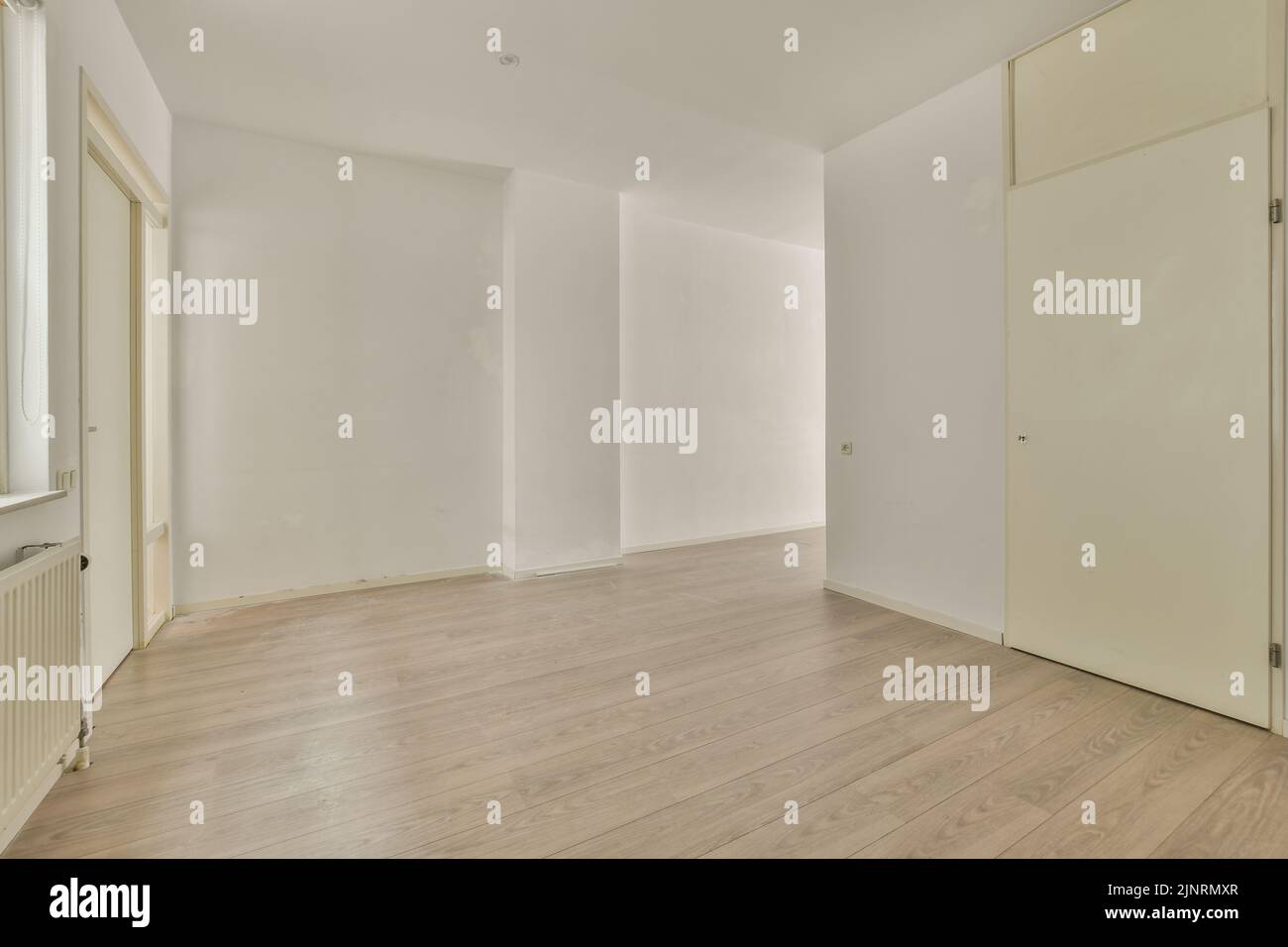 Plastic window and radiator on white wall in empty light room at home ...