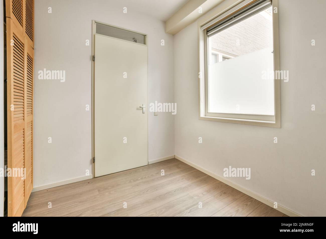 Perspective view of empty narrow hallway with white walls and wardrobe ...