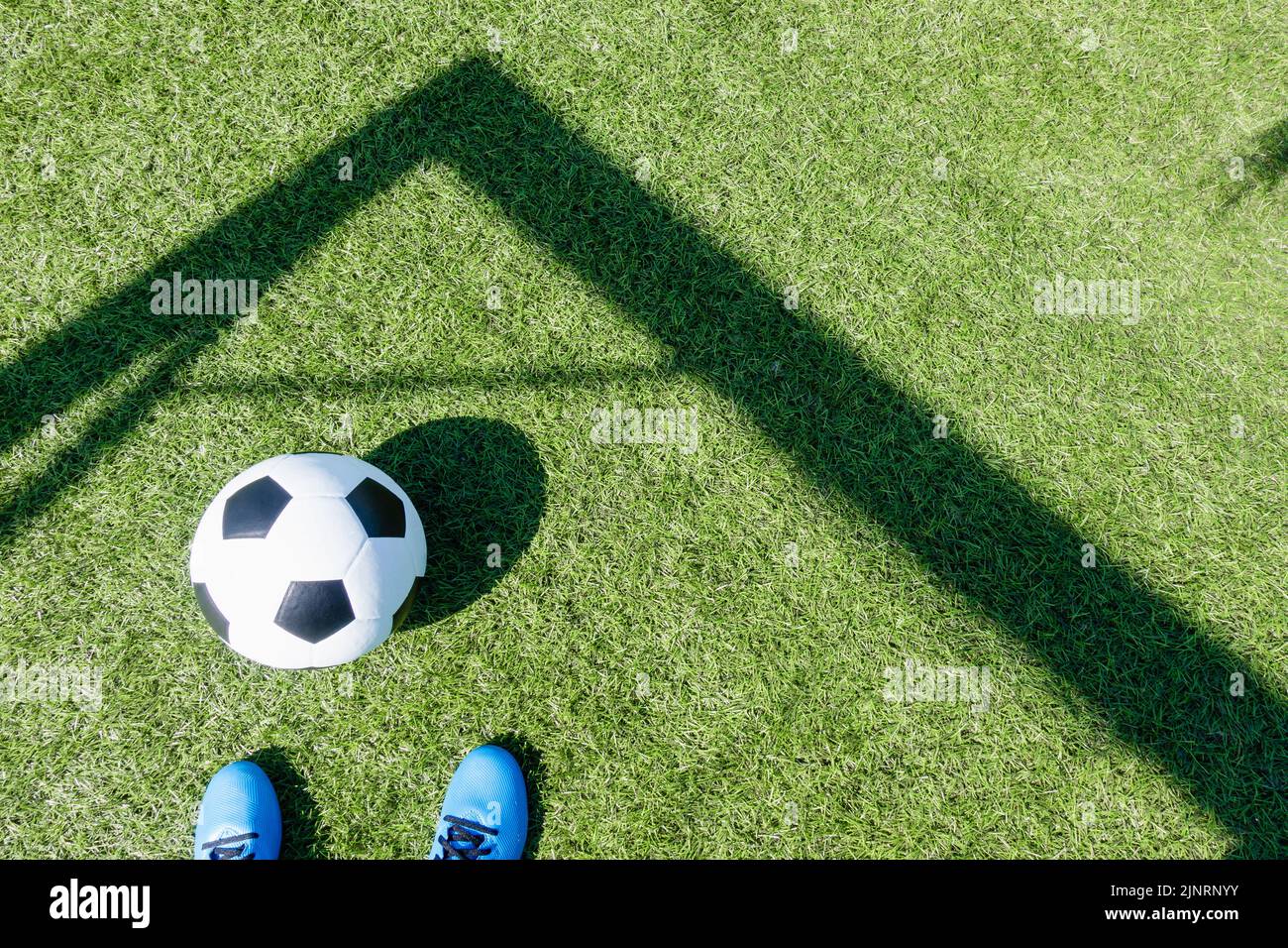 Green artificial turf soccer field with shadow from football goal net ...