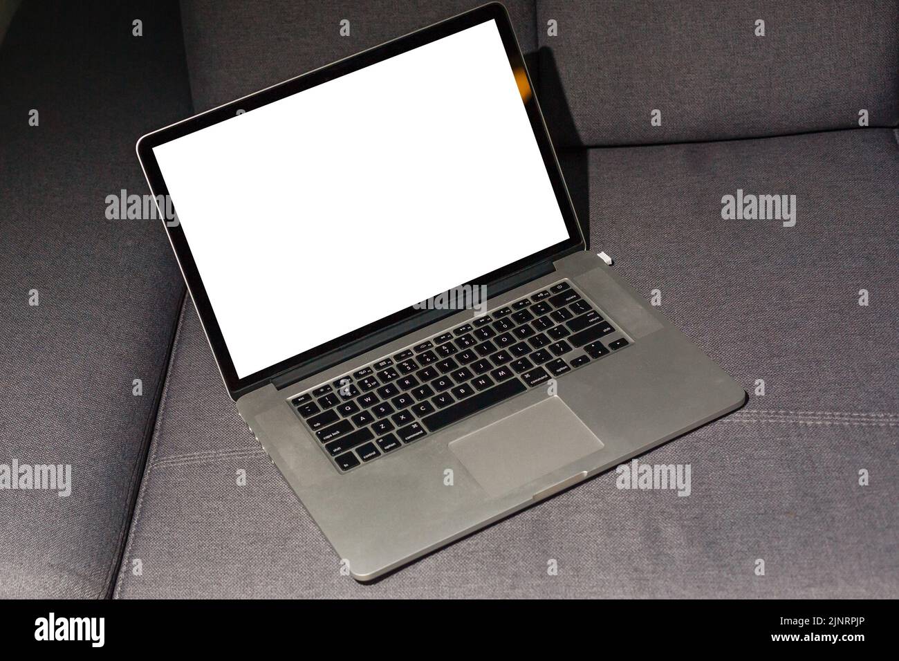 Blank screen laptop computer on sofa Stock Photo - Alamy