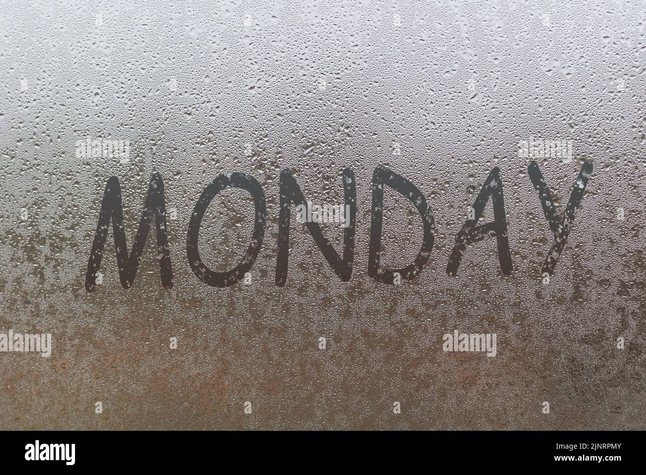 MONDAY written on the glass screen with raindrops background. Mood of ...