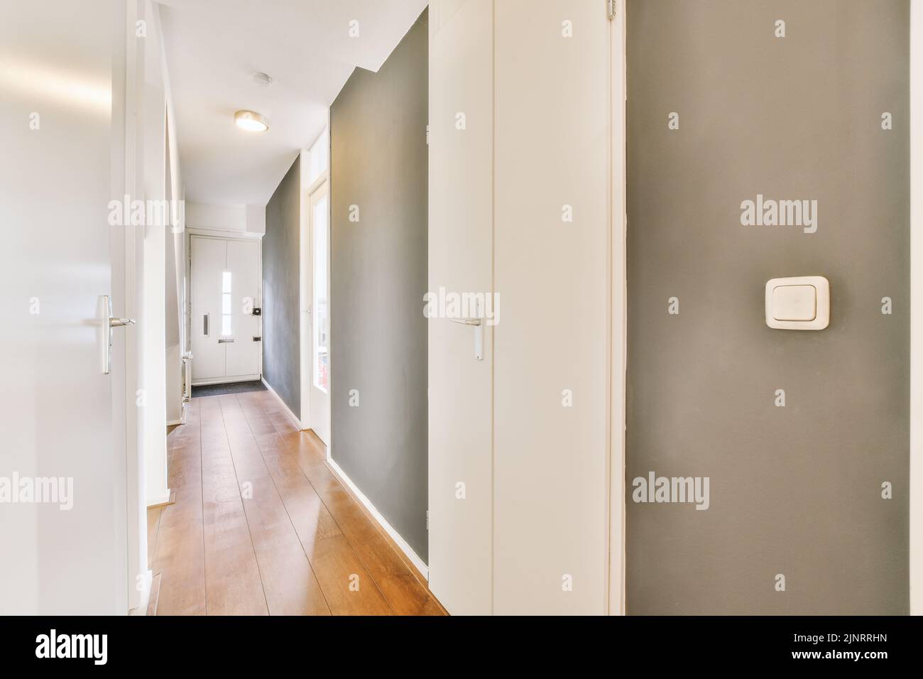 Perspective view of empty narrow hallway with white walls and wardrobe ...