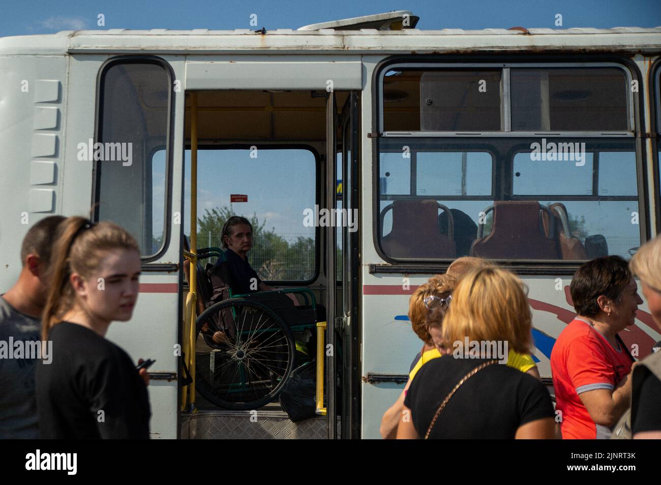 Natalia sits in an evacuation bus waiting for assistance after fleeing ...