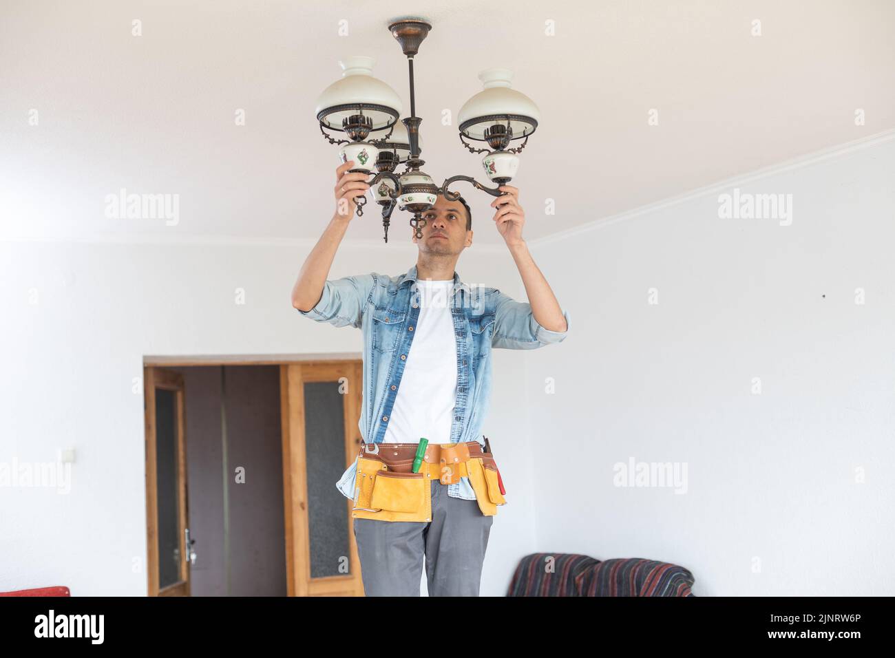 Electrician checking lighting to the ceiling in the home, technician ...