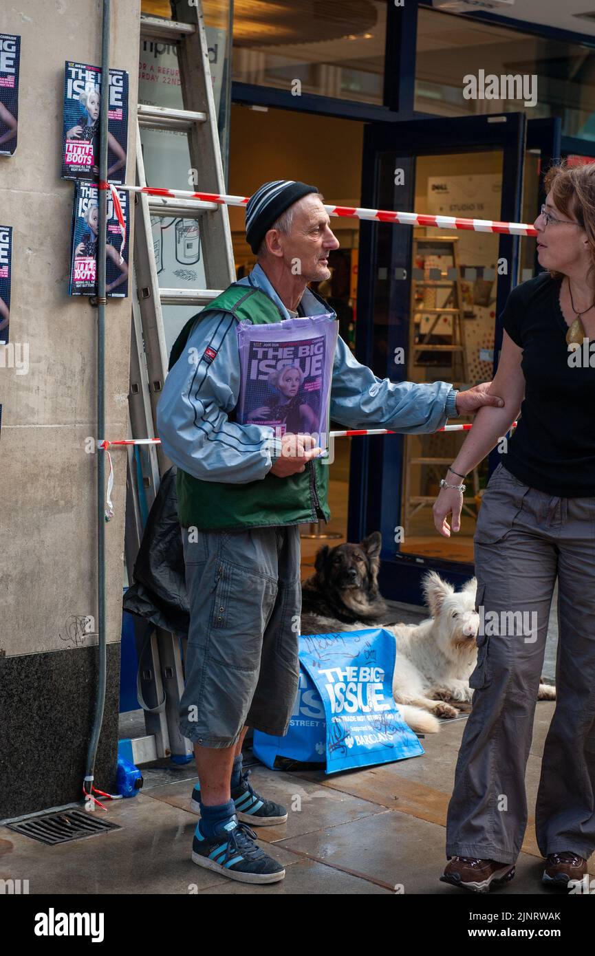 Big Issue Seller , grabs the arm of a woman walking past in Oxford ...