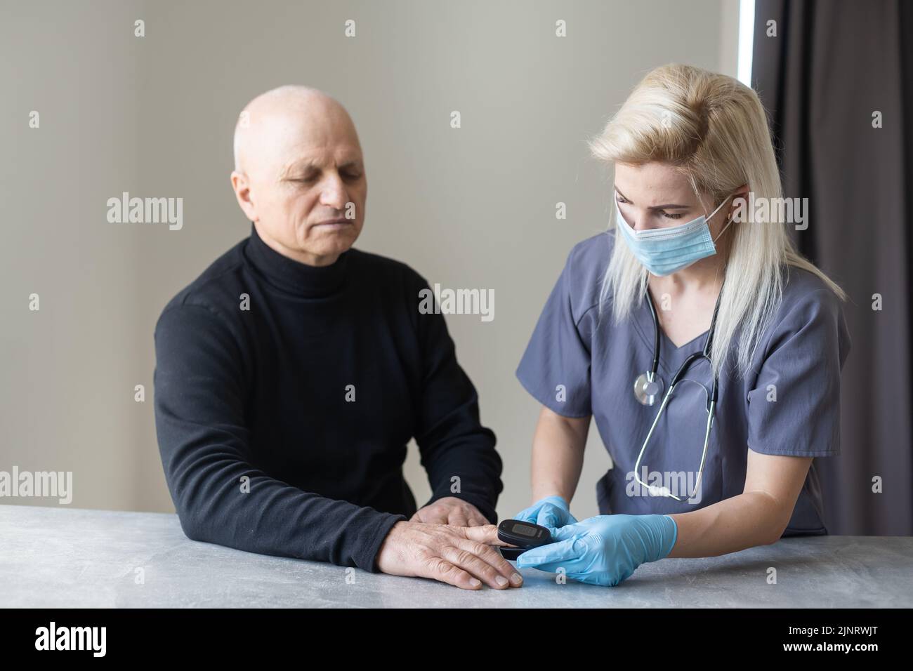 Elderly people measuring their pulse with their fingertips at a long ...
