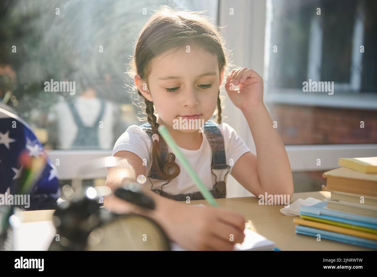 Portrait of adorable schoolgirl studying the writing lesson ...