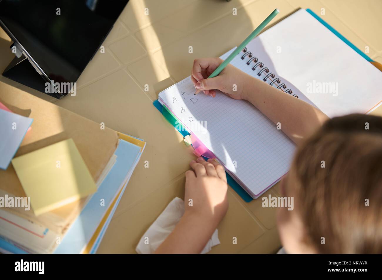 View from above with details of a schoolgirl hand holding a pencil and ...