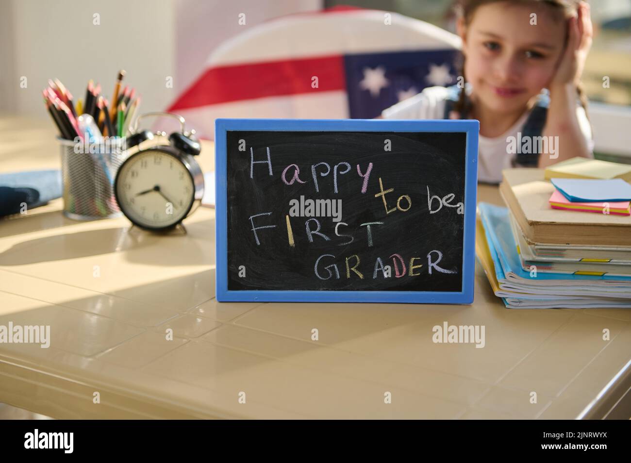 Focus on blackboard with text - Happy to be a first grader - against a ...
