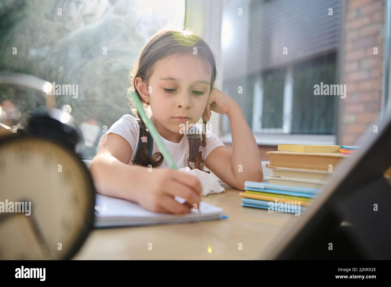 Beautiful sunbeams fall on the classroom through large windows while a ...