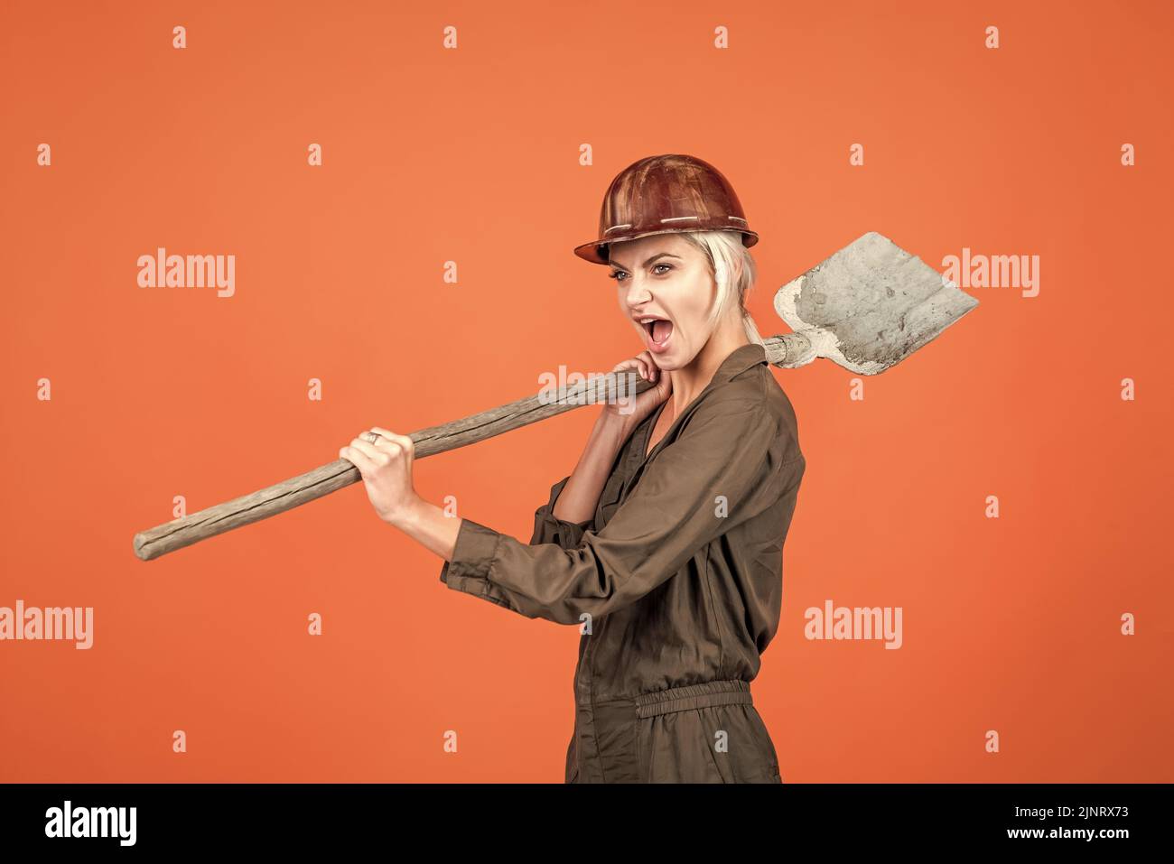 digger. woman in boilersuit and helmet. female builder hold shovel ...