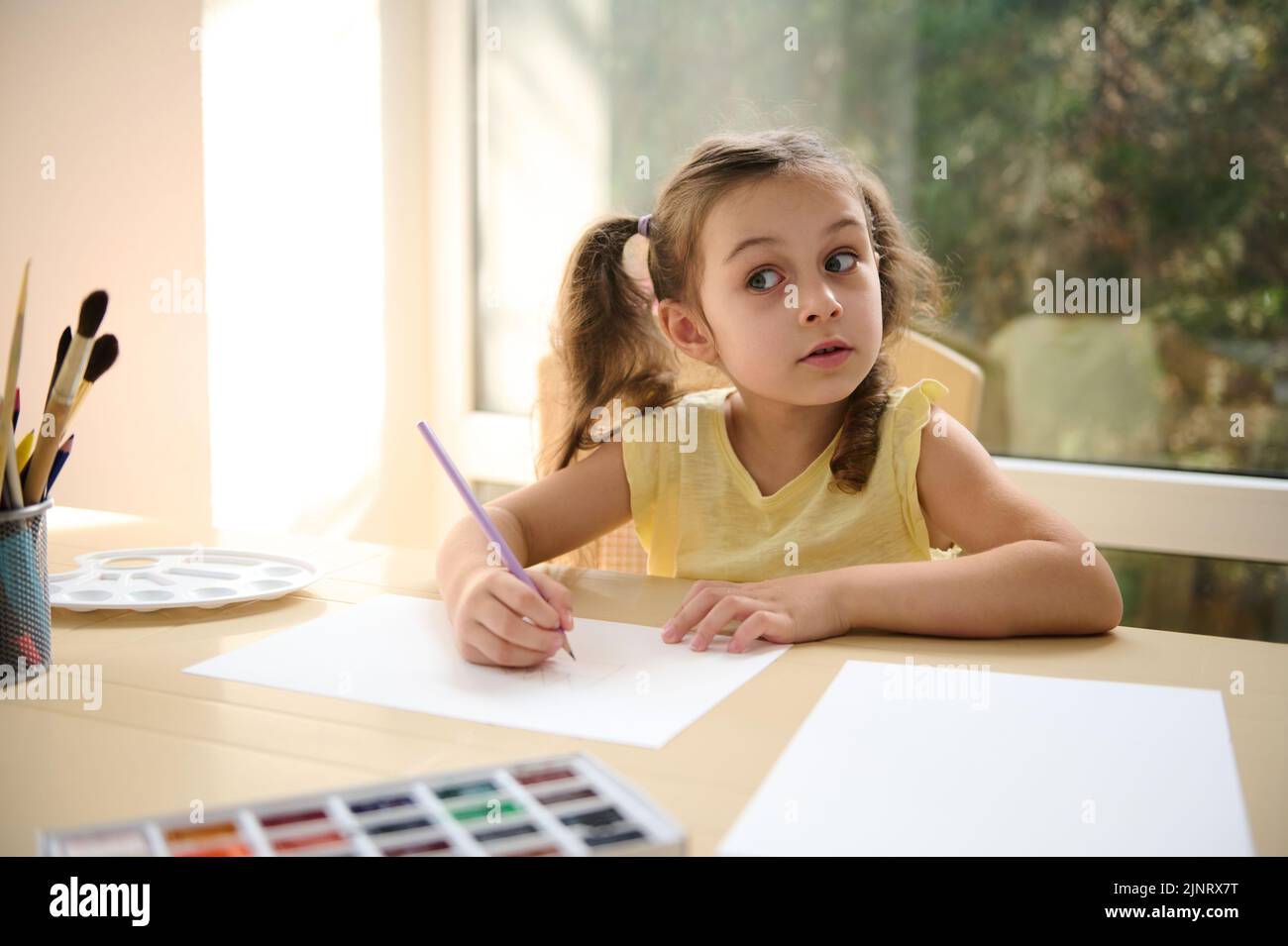 Dedicated, talented and creative child, inspired little girl painting ...