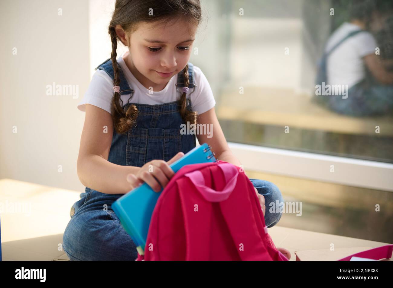 Happy and inspired first grader, European smart schoolgirl folds her ...