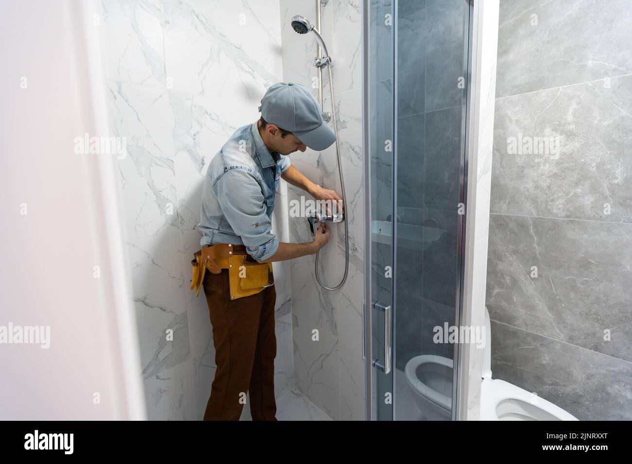 repairmen in uniform measuring modern shower cabin in bathroom Stock ...