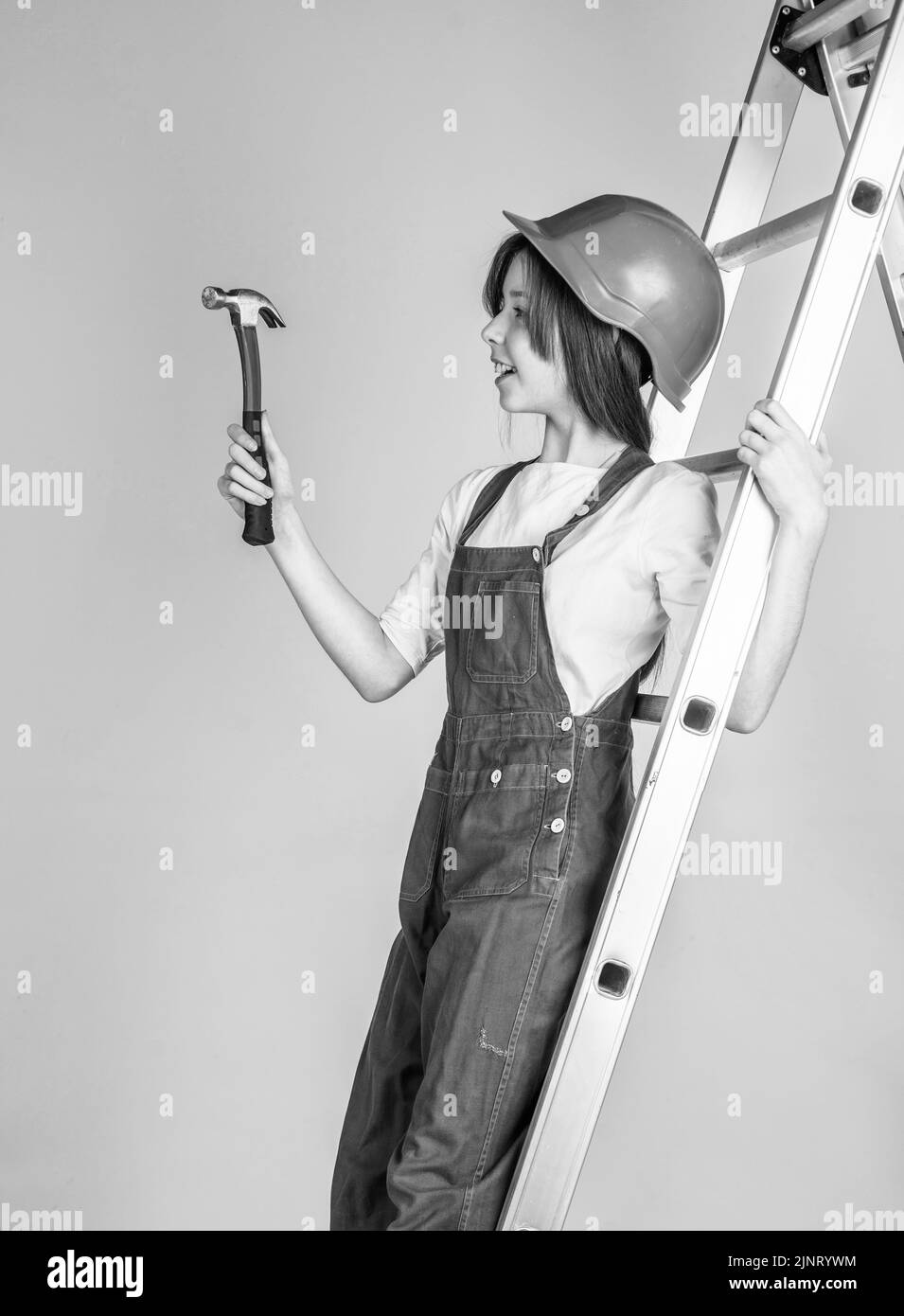 girl kid in hard hat on construction site use ladder and hammer, mechanic Stock Photo - Alamy