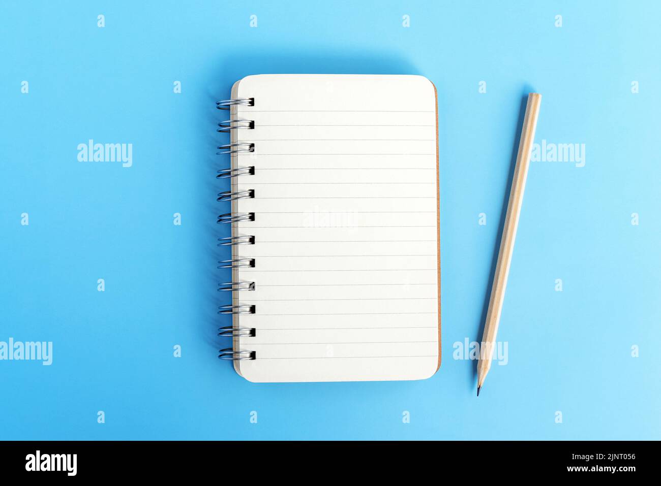 Note pad and pencil on blue background Stock Photo - Alamy