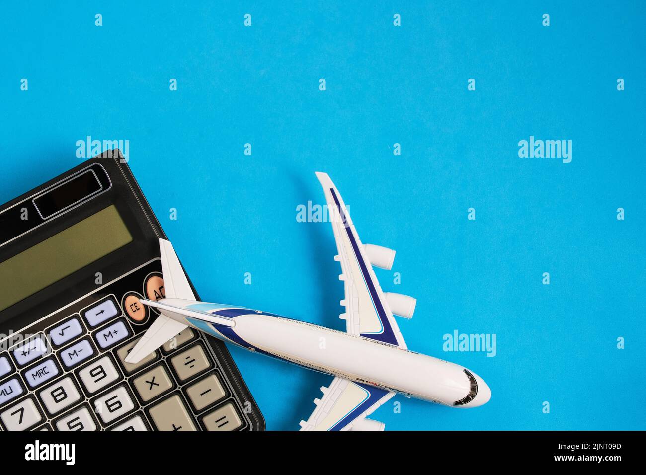 Airplane model and calculator blue background.Concept of costs or ...