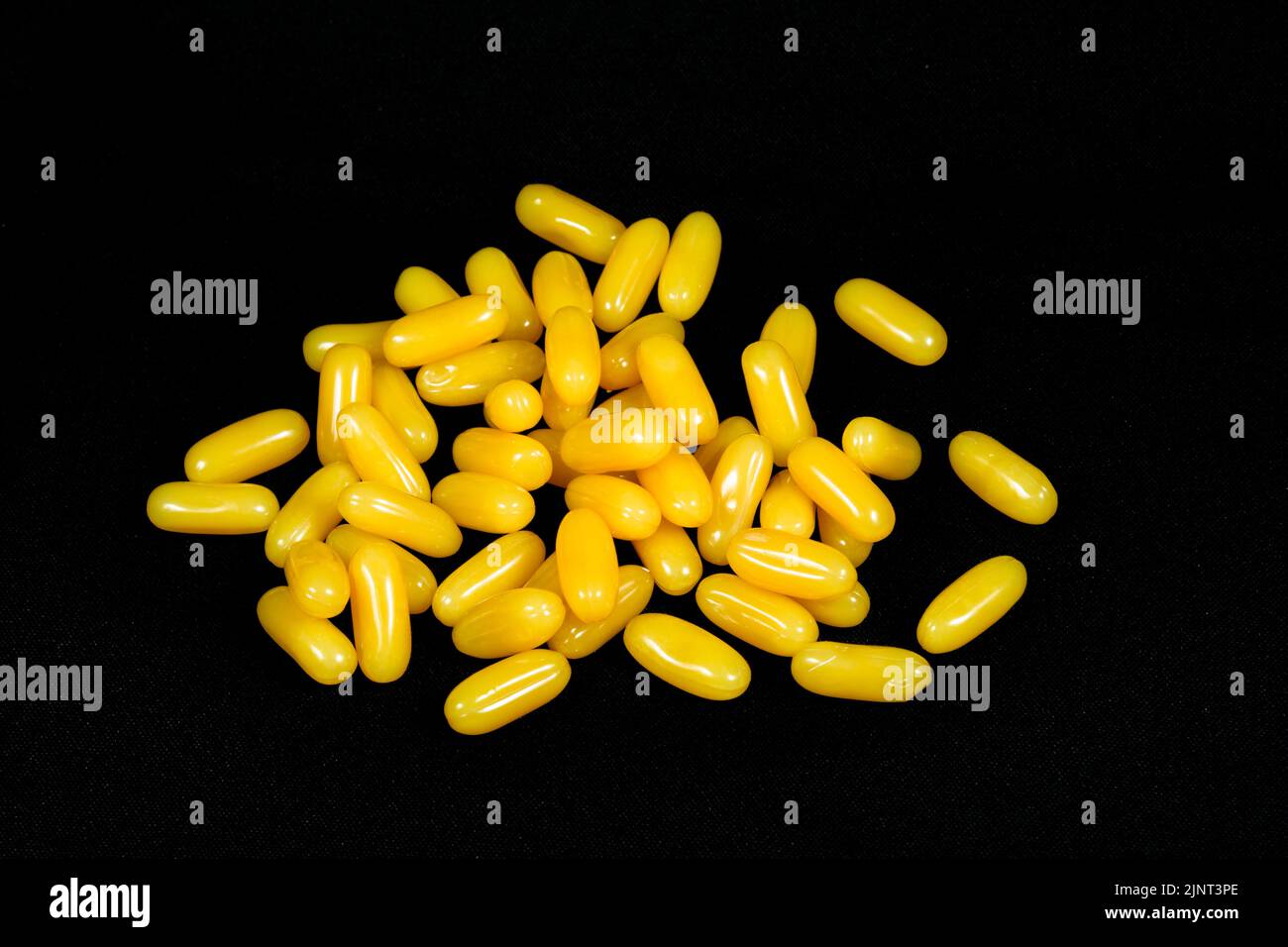 Some yellow fatty acid pills isolated on black background Stock Photo ...