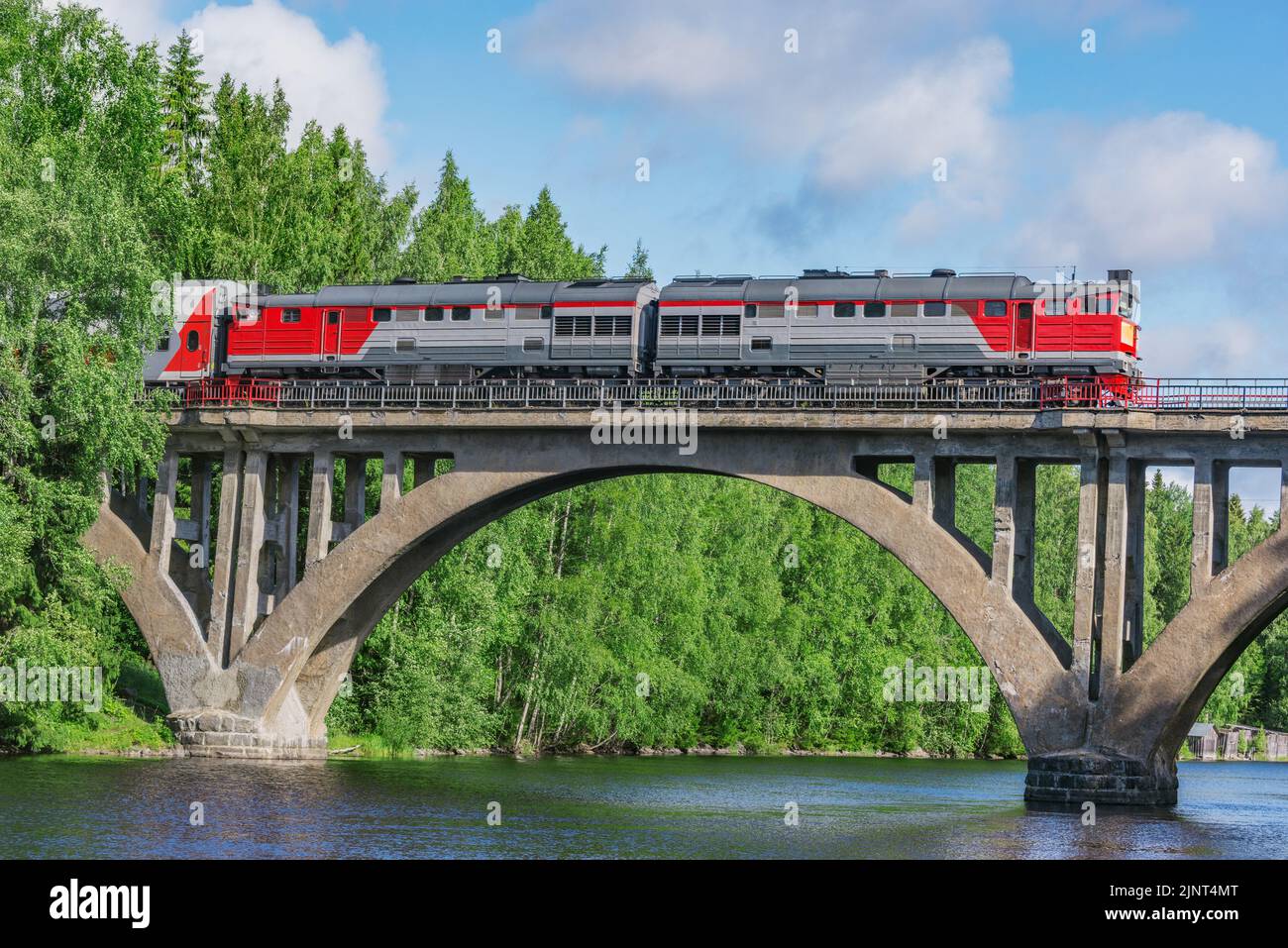 Passenger intercity train moves above the river Stock Photo - Alamy