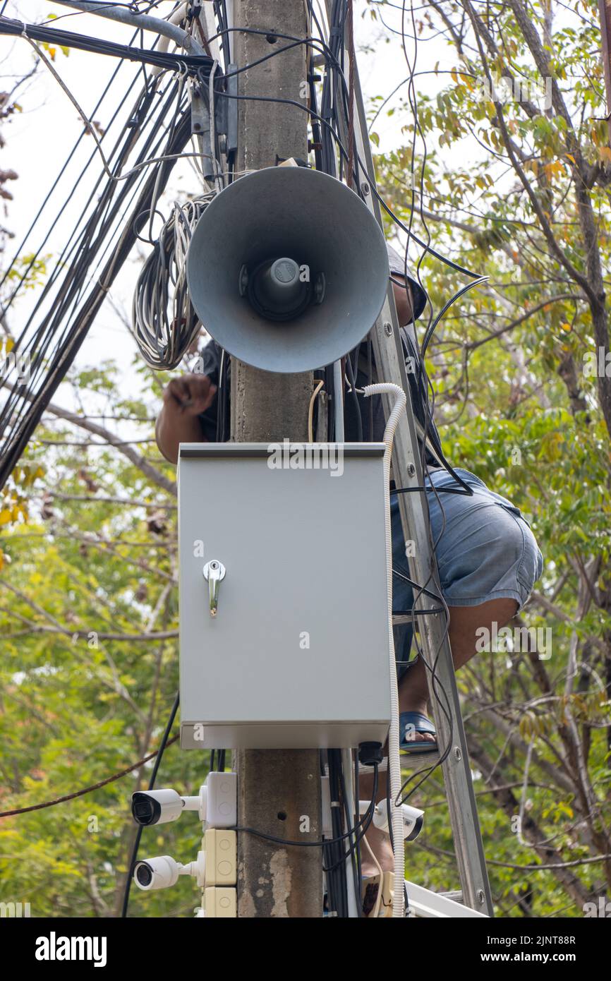 A man performs maintenance on a pole with a megaphone Stock Photo - Alamy