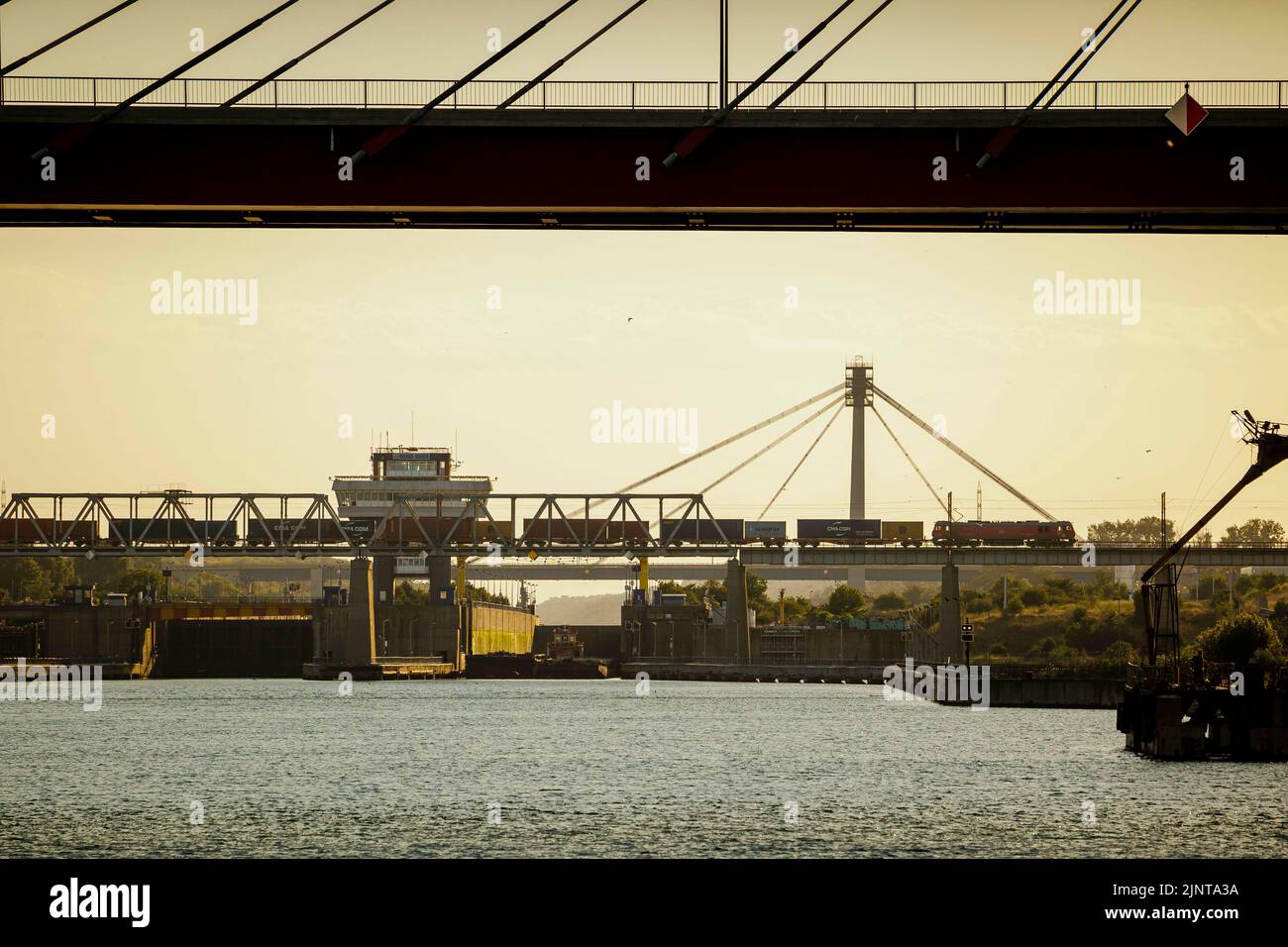 A freight train leaves the port of Constanta over a bridge. In the port ...