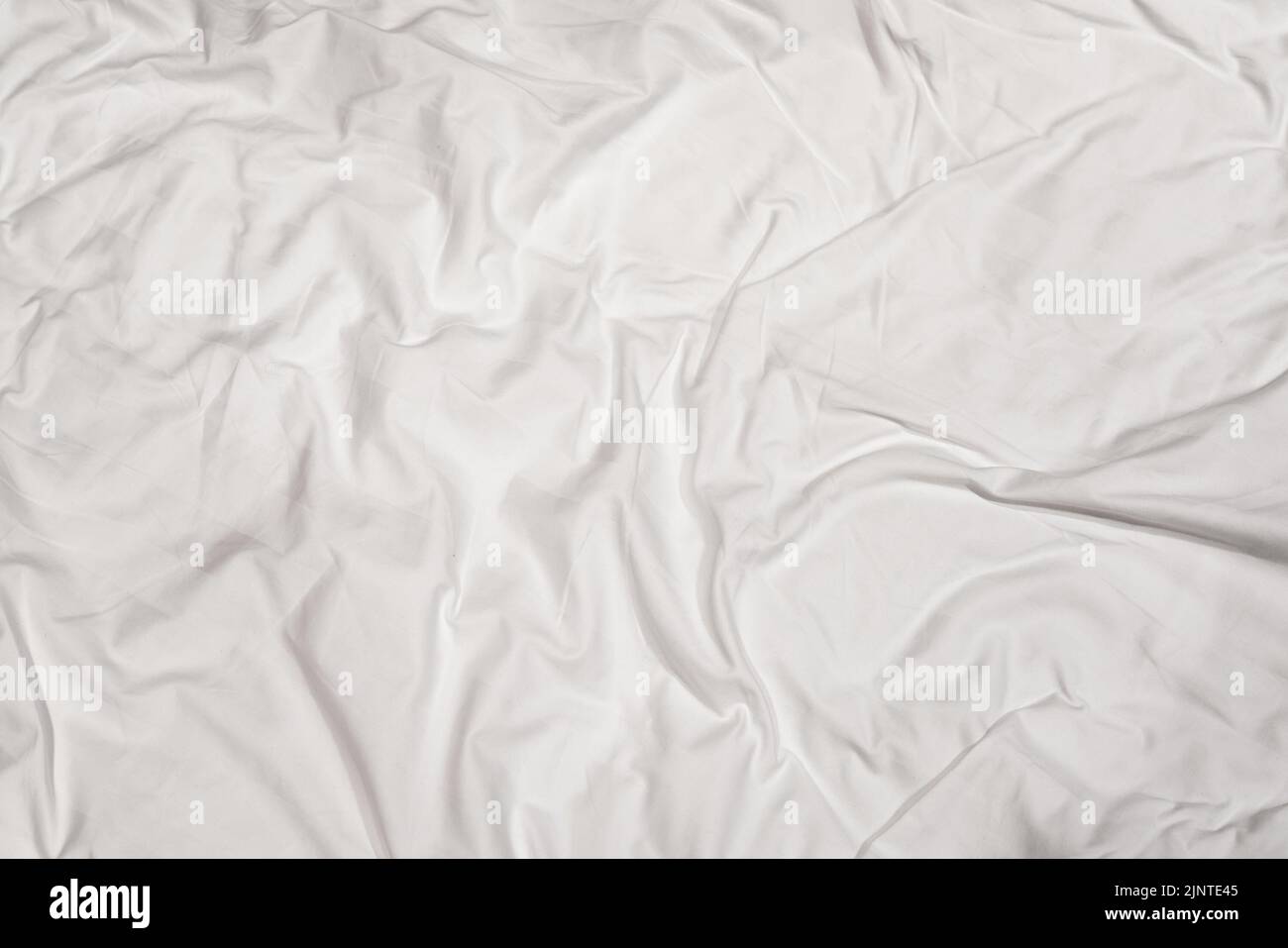 Closeup texture of crumpled white bed sheet with messy abstract pattern ...