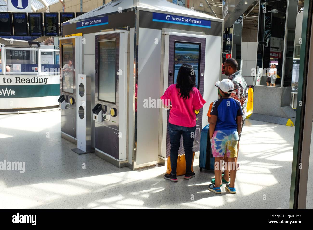 A family buying train tickets from a machine at Reading rail station in ...