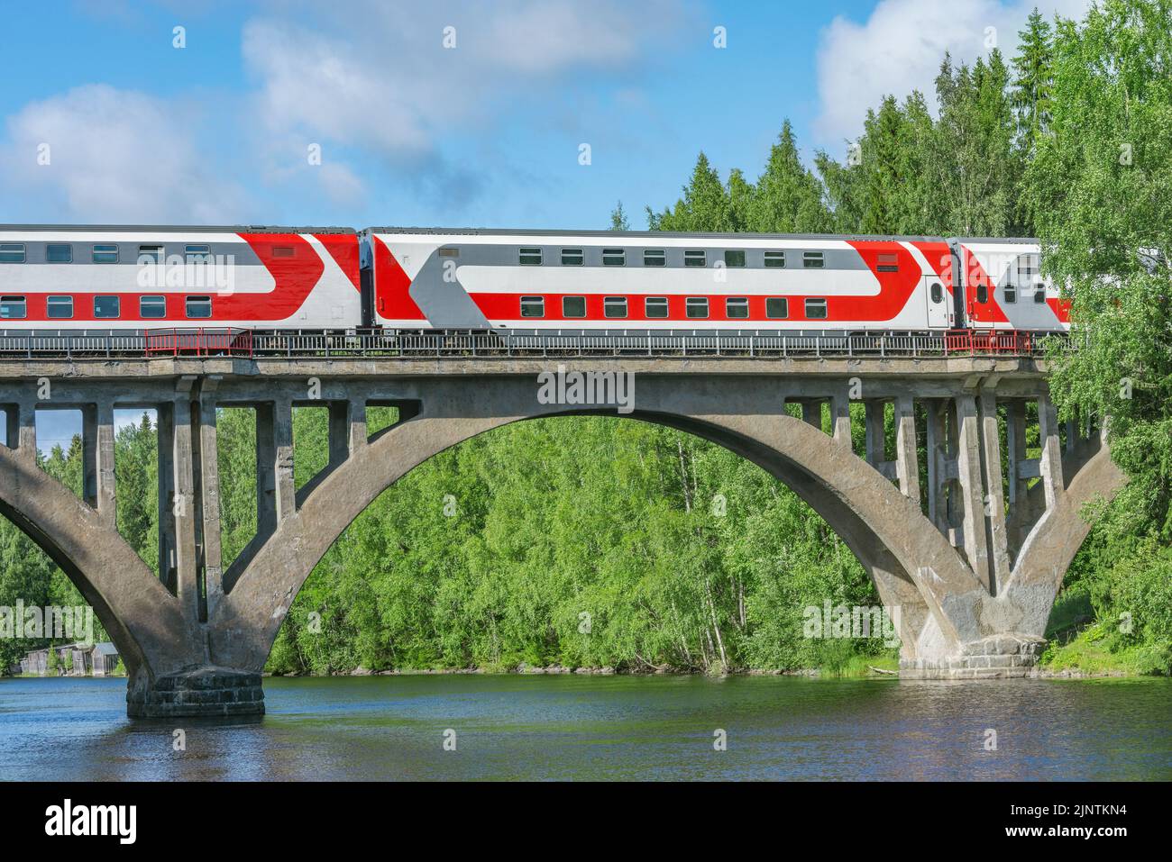 Passenger intercity train moves above the river Stock Photo - Alamy
