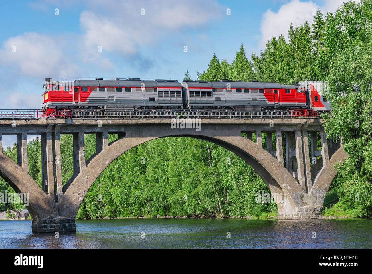 Passenger intercity train moves above the river Stock Photo - Alamy