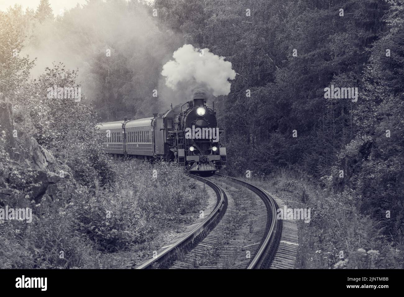 Retro steam train approaches to the station Stock Photo - Alamy