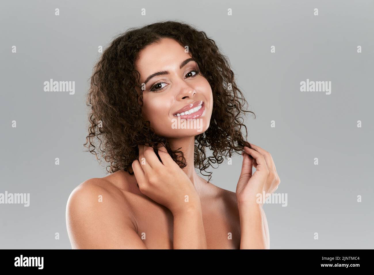 Her skin glows and her face radiates with a smile. Studio shot of a ...