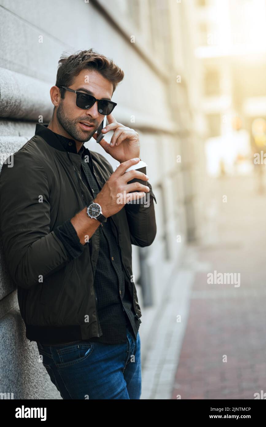 Would you like to meet up. a handsome young man making a phonecall ...