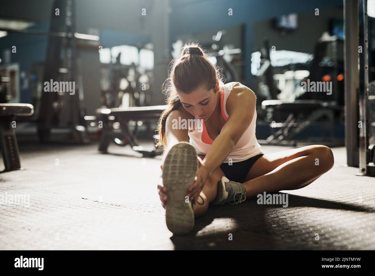 Stretch beyond your limits. a young woman doing stretch exercises at ...