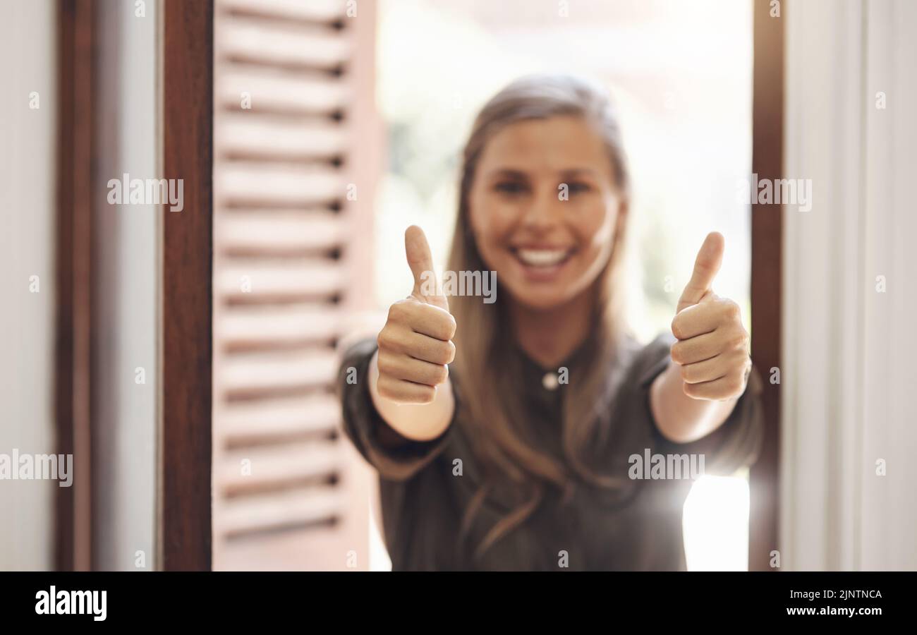 Thumbs up from a happy woman smiling while showing a hand winning ...