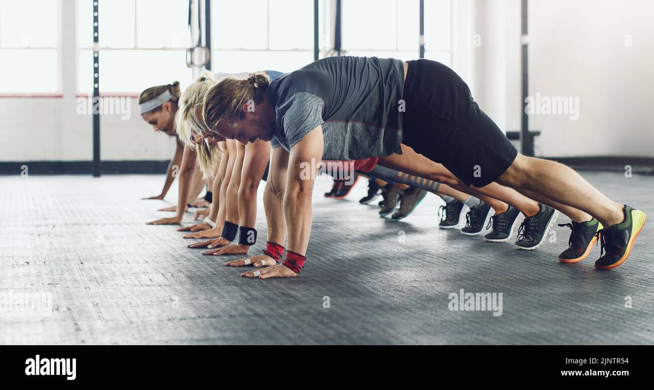 Gym - the body transformation station. a group of young people doing ...