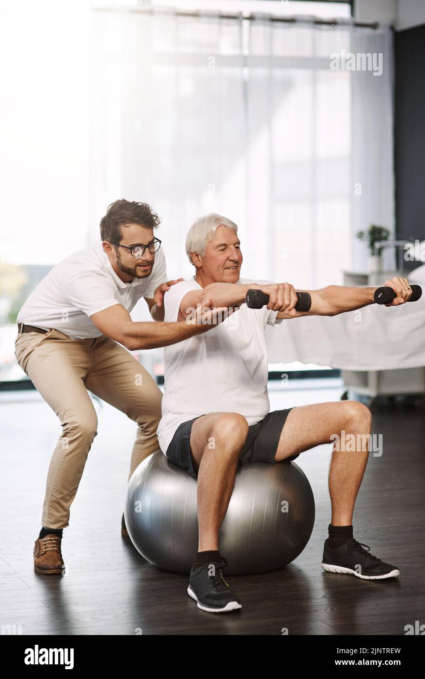 And hold... Full length shot of a young male physiotherapist working ...